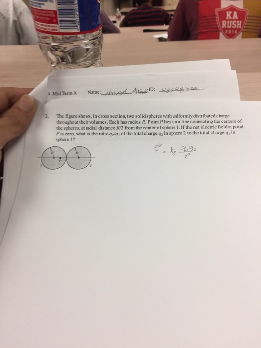 Solved The figure shows, in cross section, two solid spheres | Chegg.com