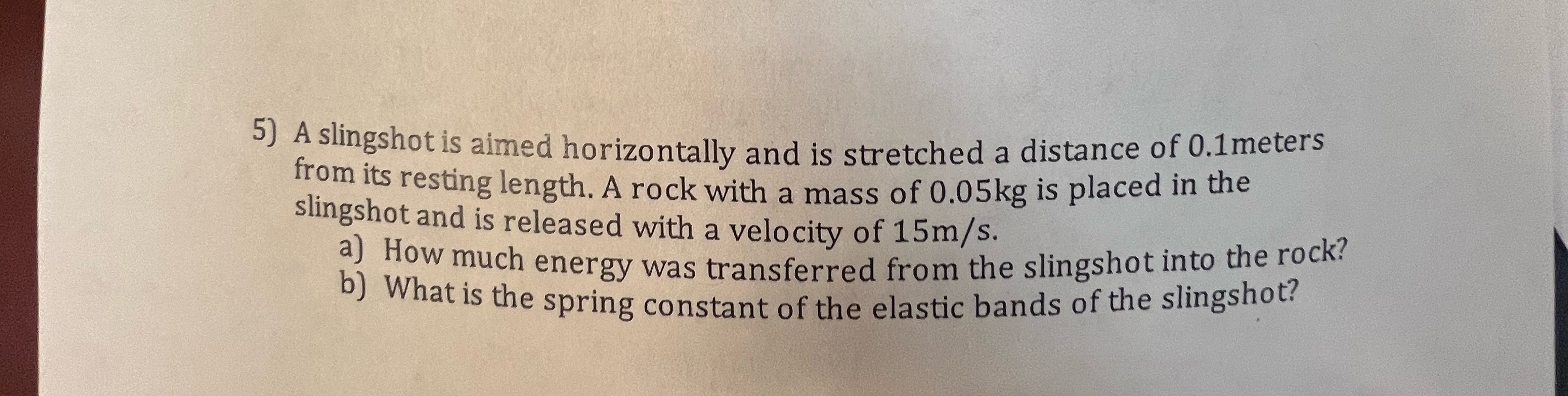 Solved A slingshot is aimed horizontally and is stretched a | Chegg.com